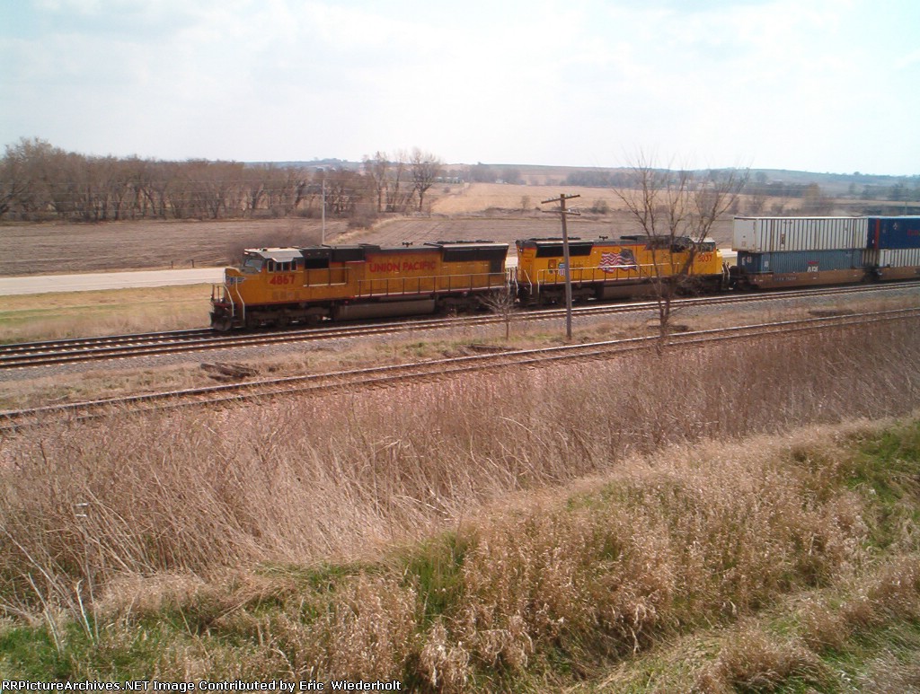 UP SD70Ms 4867 & 5037 flying east with stacker.